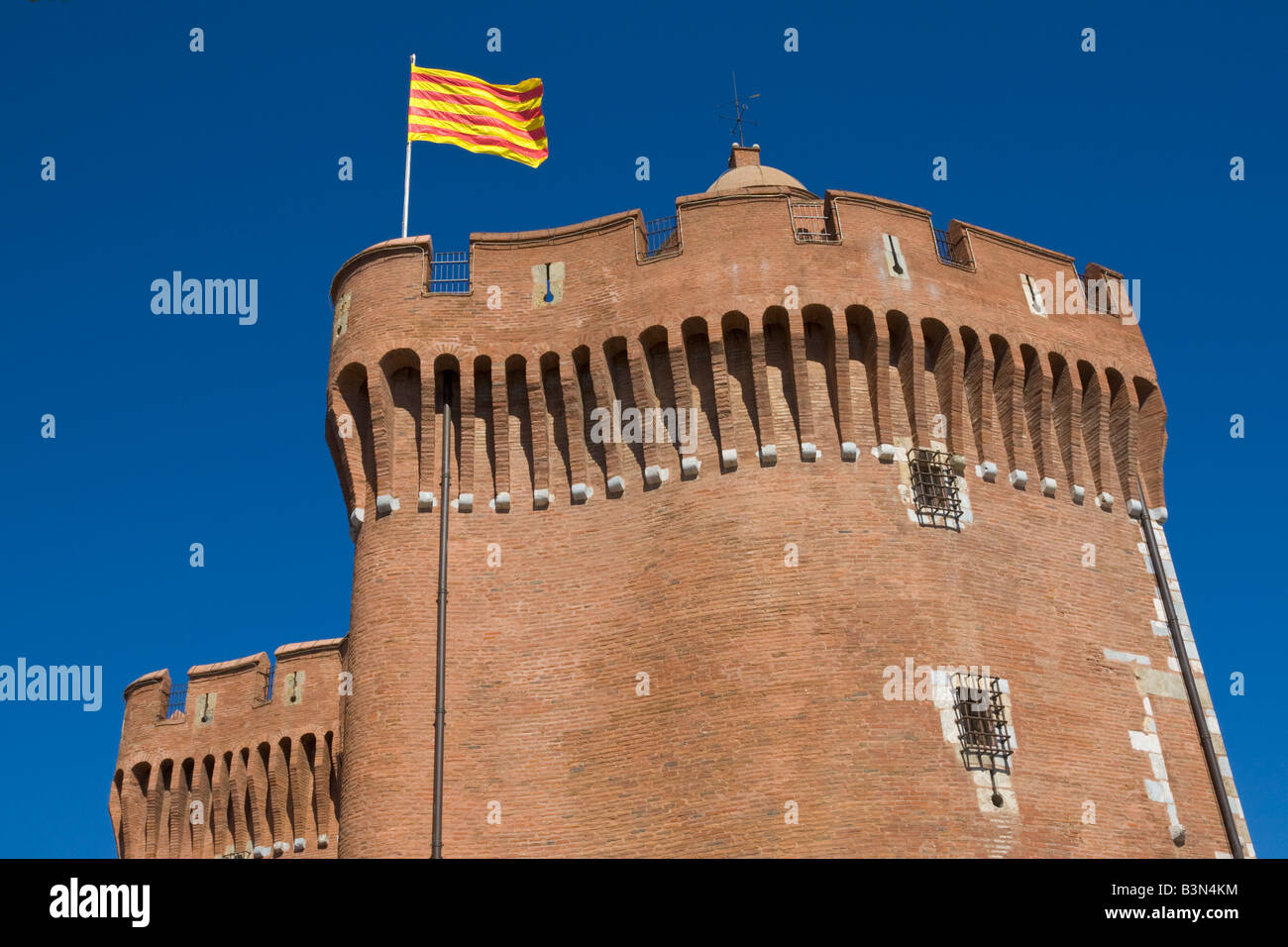 The Catalonian flag is blowing above the city gate "Le Castillet" in ...