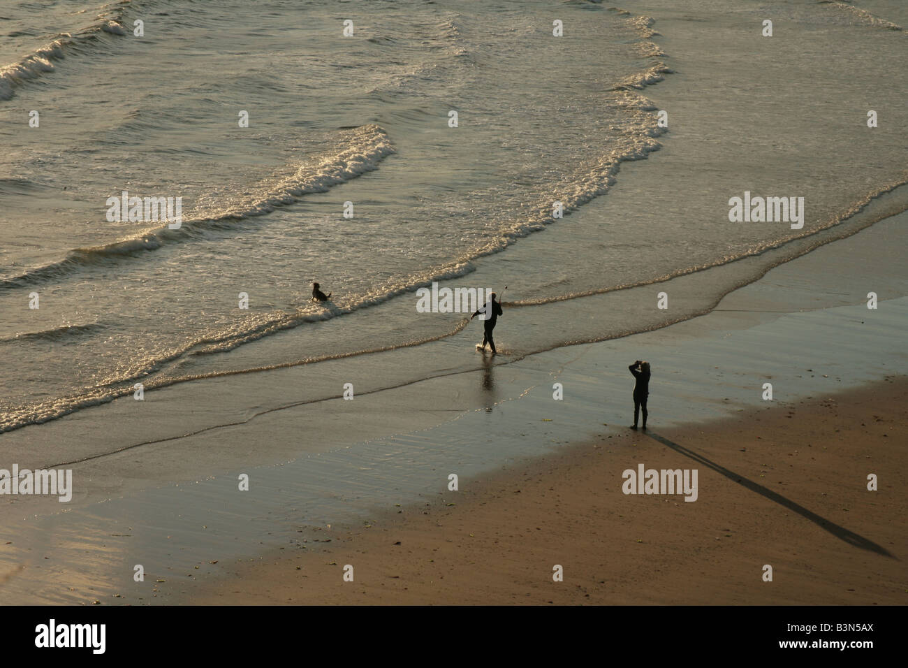 Couple and dog on Manorbier beach Wales Stock Photo - Alamy