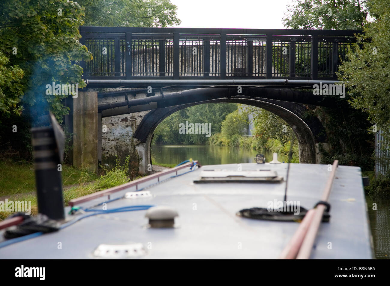 British Waterways Grand Union Canal. Narrowboat approaches bridge over ...