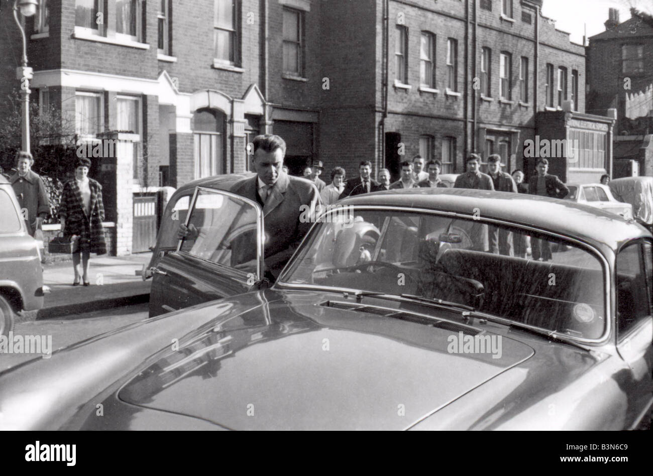 VICTIM crowds watch Dirk Bogarde during filming in London for 1961 Rank ...