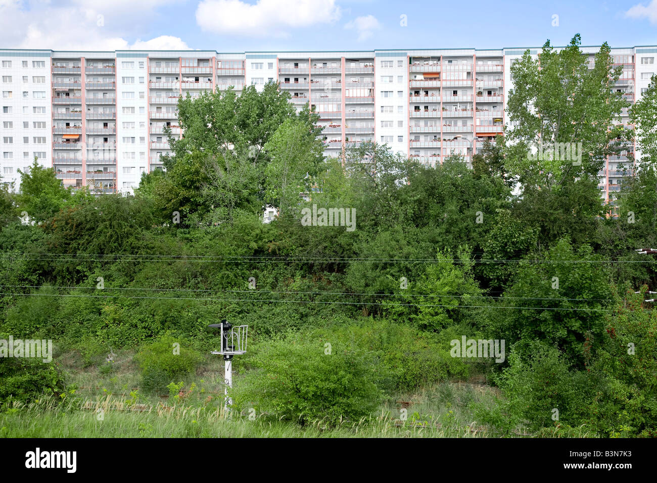 Housing block with trees in front Stock Photo - Alamy