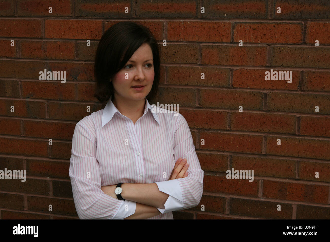 a portrait of a beautiful female solicitor leaning on a fence and ...