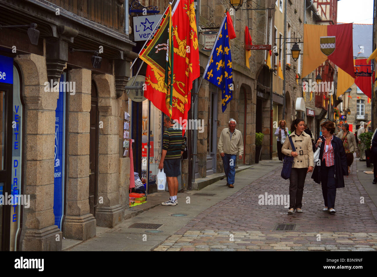 cobbled shopping street with flags and tourists, Dinan, Cotes d'Armor ...