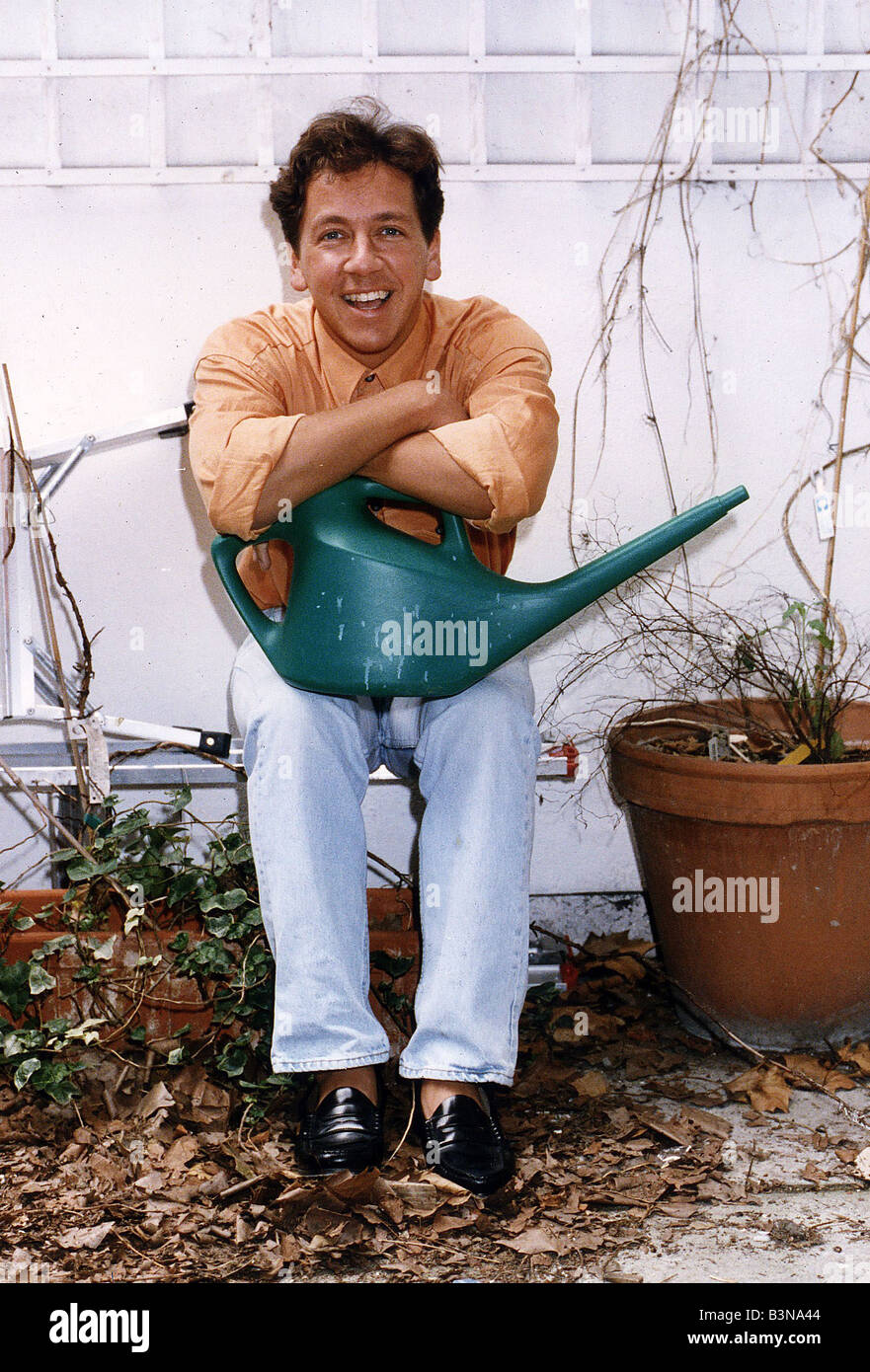 Ross King TV presenter in his garden holding a watering can Stock Photo ...