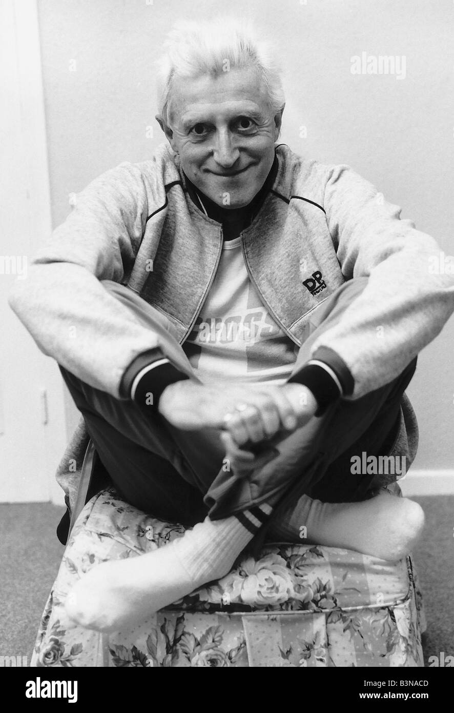 Jimmy Saville DJ TV Presenter sitting cross legged on chair Stock Photo ...