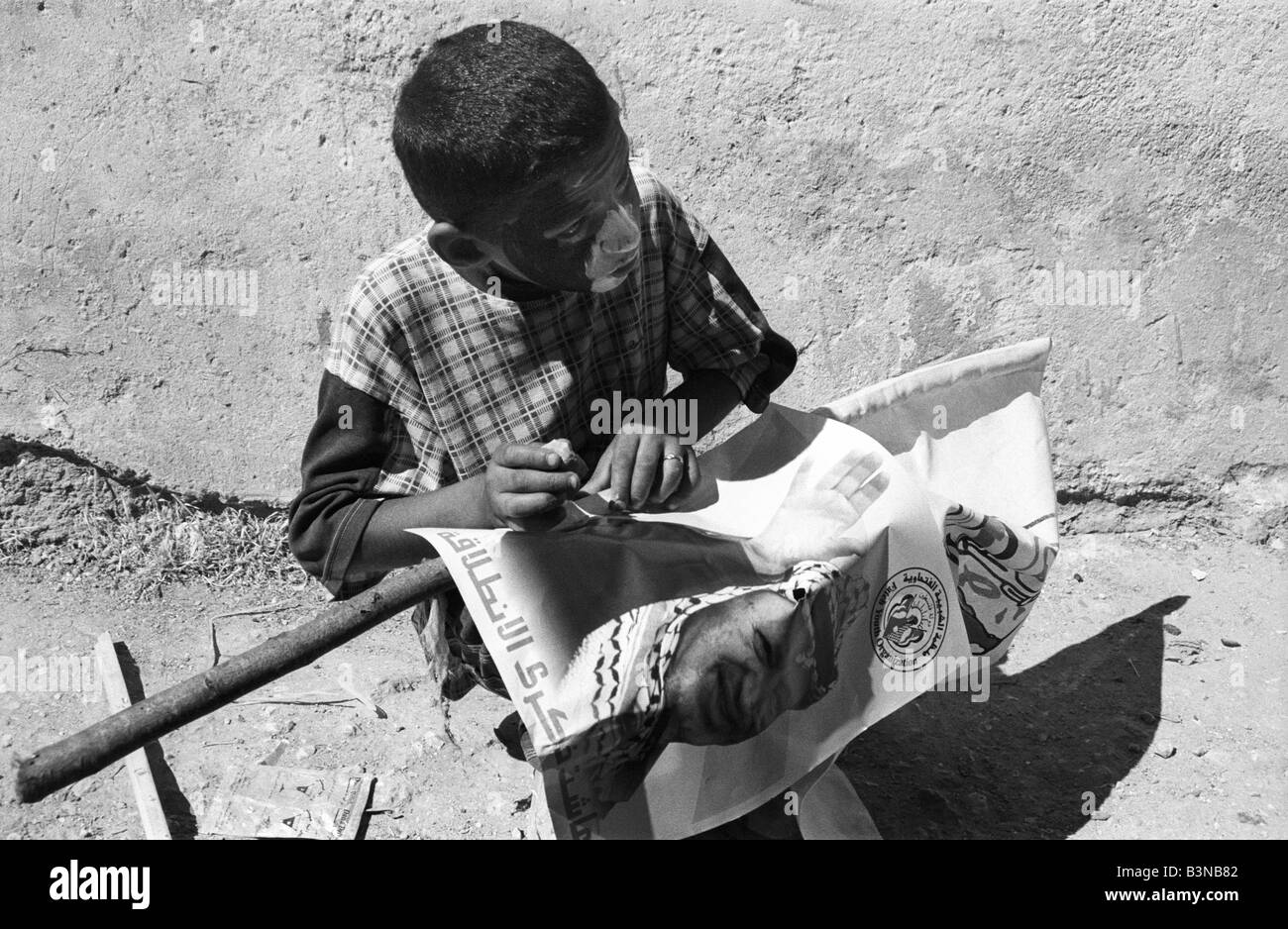 a young palestinian child prepares a banner prior to a protests against ...