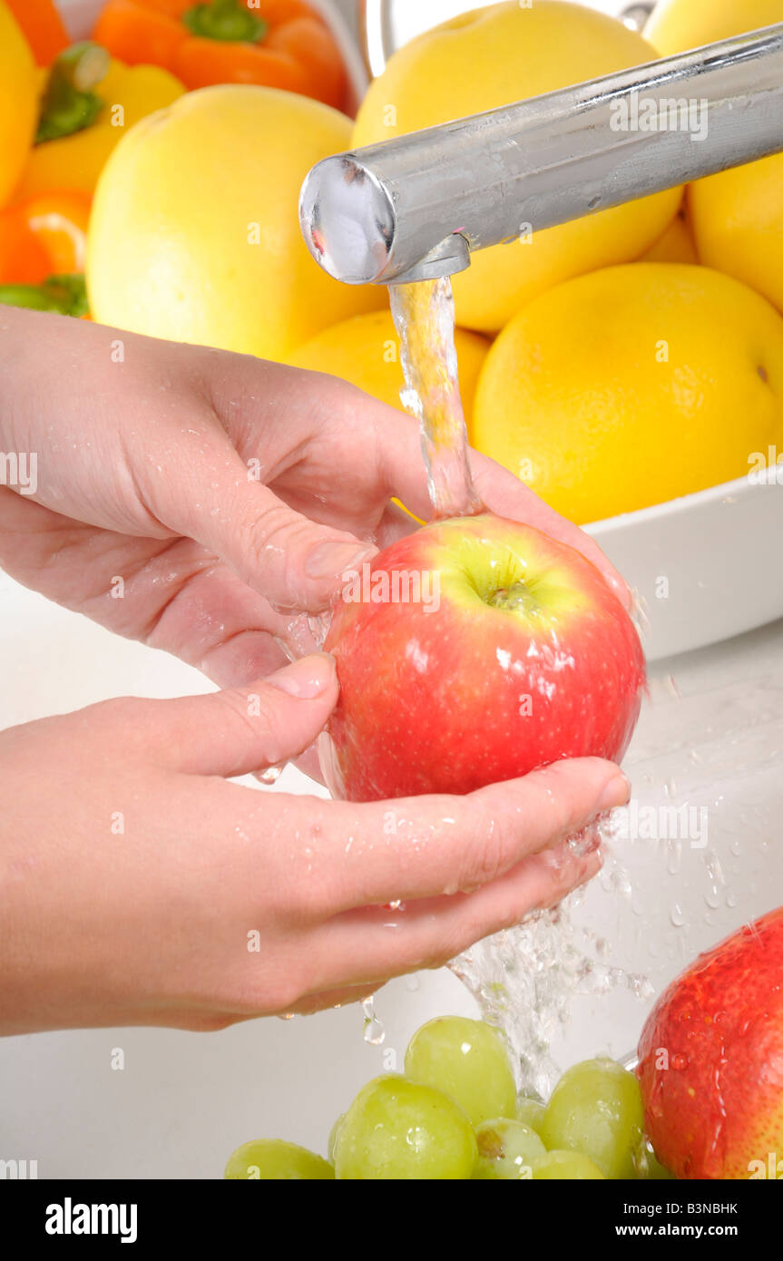 WOMAN WASHING APPLE AT KITCHEN SINK Stock Photo - Alamy