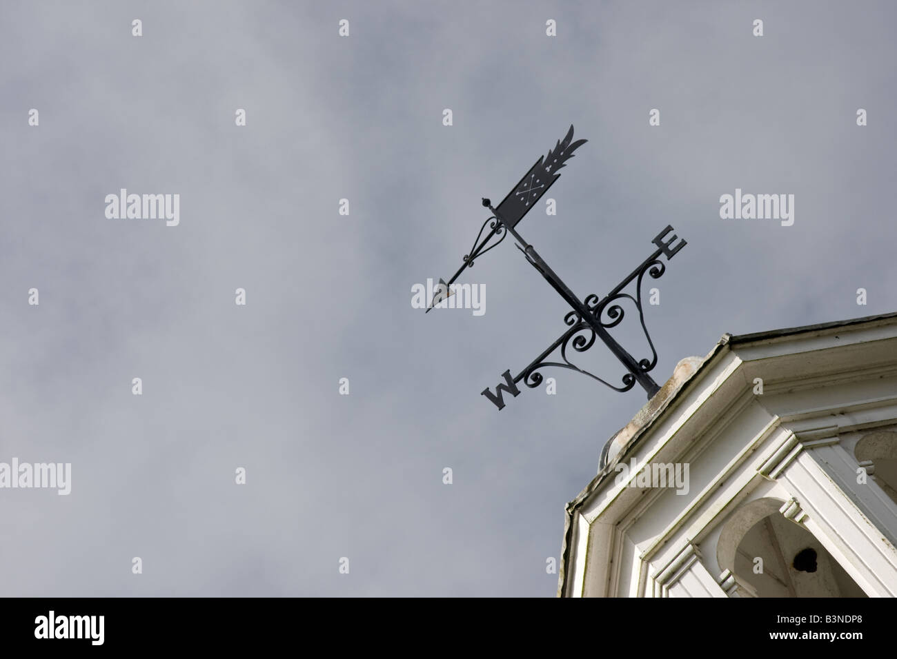 Weather wind vane arrow points west east on a roof in the sky Stock ...