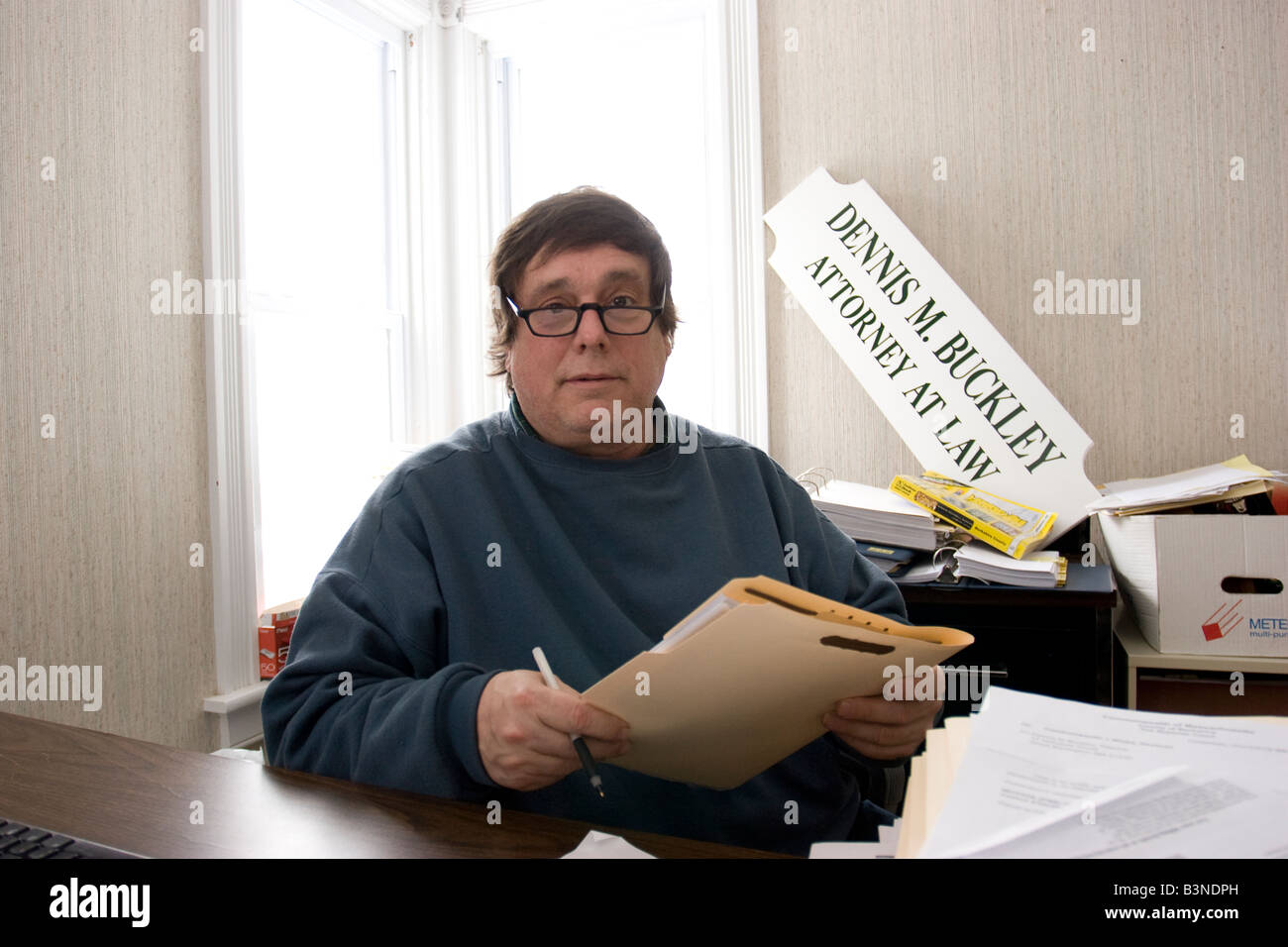white male sitting at messy desk and computer with papers around him ...