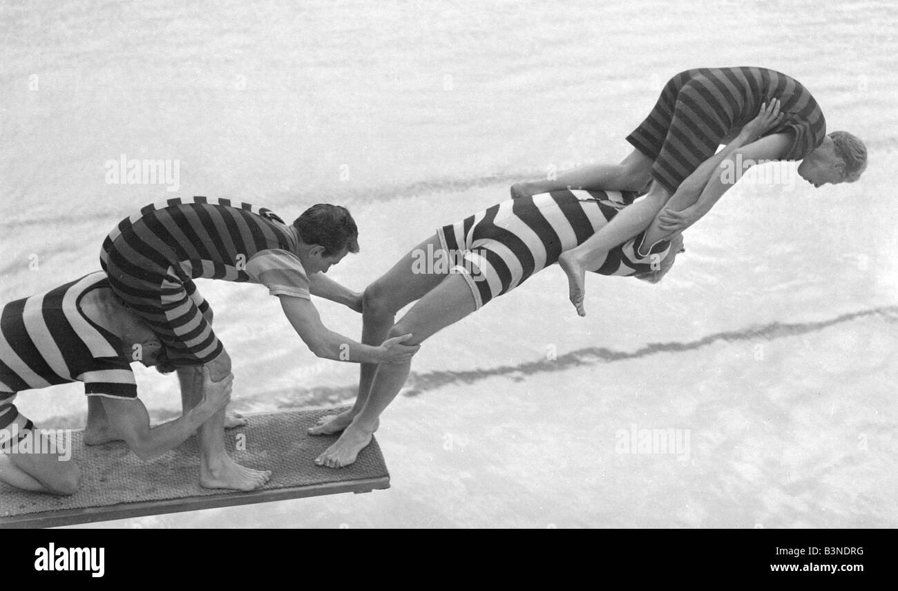 Acrobats from the Leon Marco Water Show clown about on a diving board ...