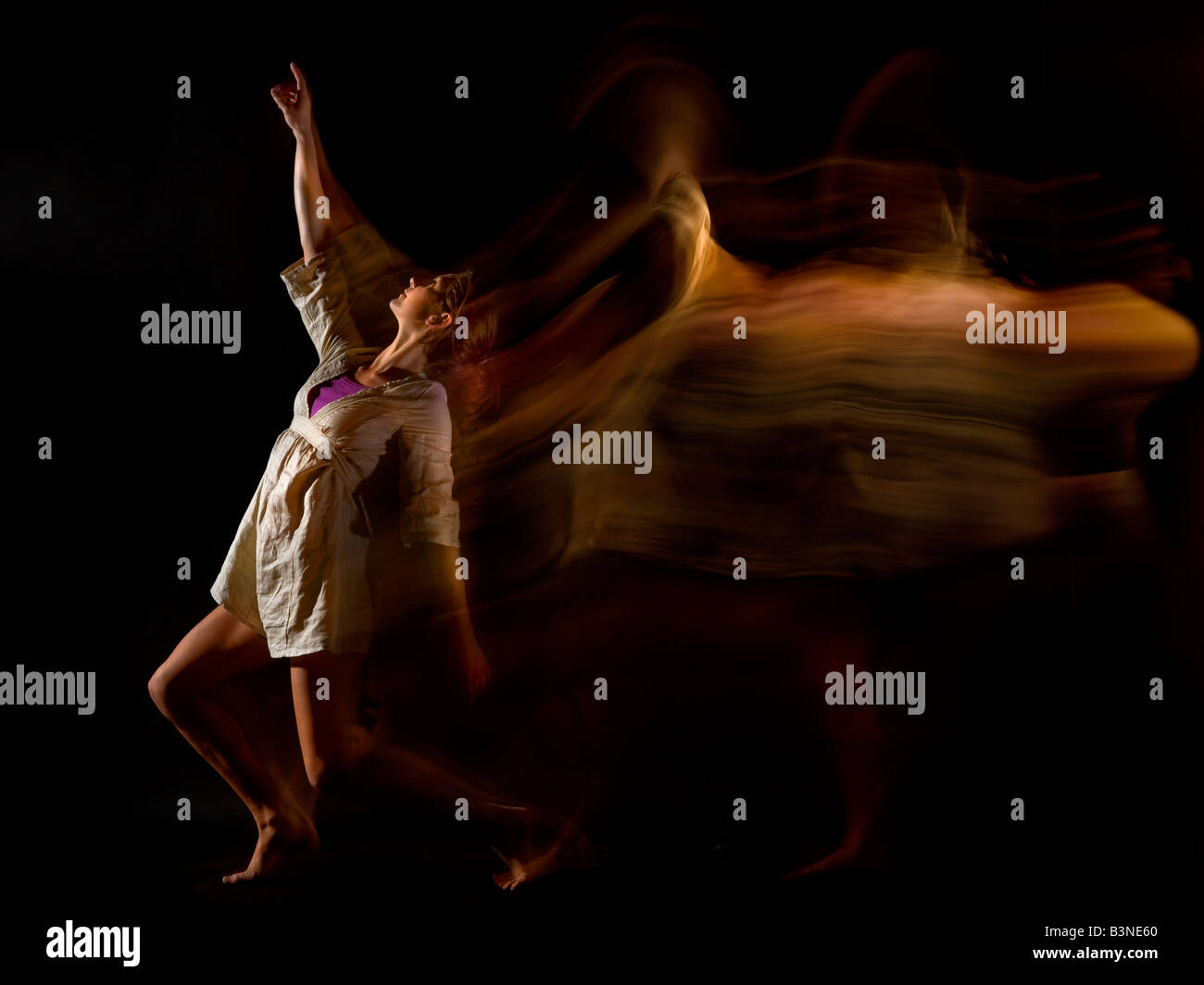 dancer jumping through the air showing motion as trails of light impact ...