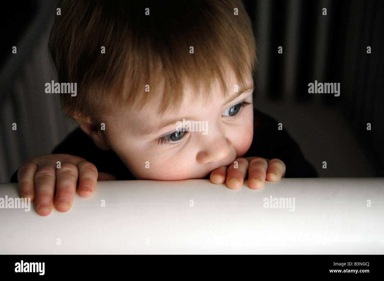 serious caucasian boy looks out window from inside crib Stock Photo - Alamy