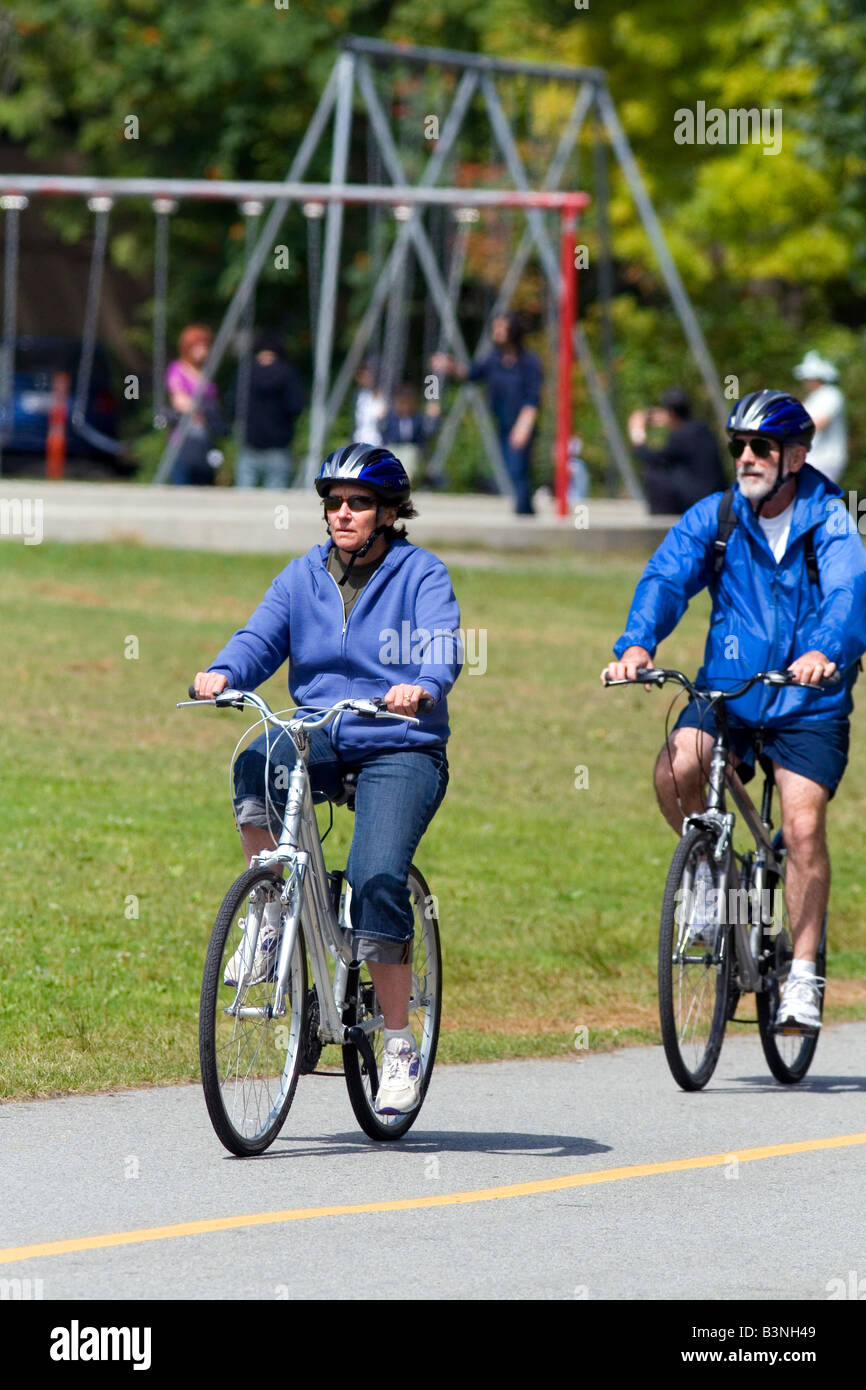 Bicyclists ride along the Seawall path in Stanley Park at Vancouver ...