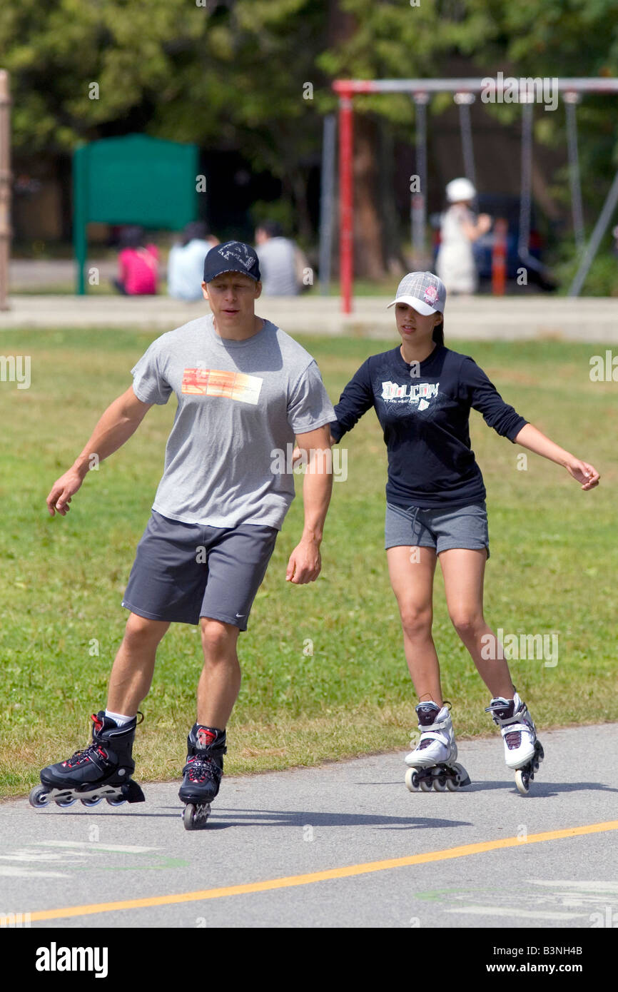 Couple inline skating at park hi-res stock photography and images - Alamy