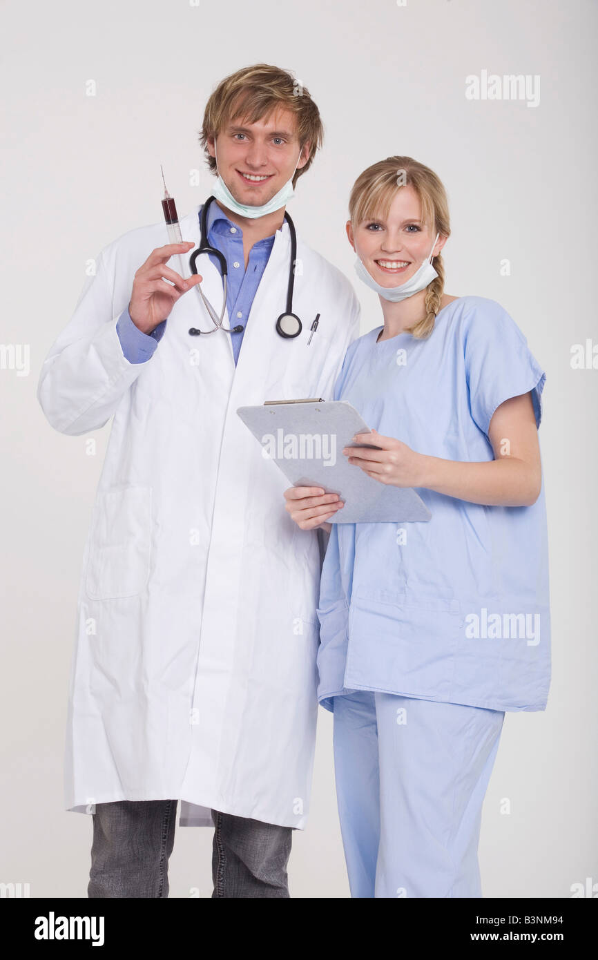 Young couple wearing doctor's overall, smiling Stock Photo - Alamy