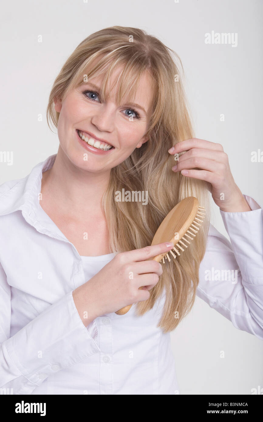 Young woman combing her hair, portrait Stock Photo - Alamy
