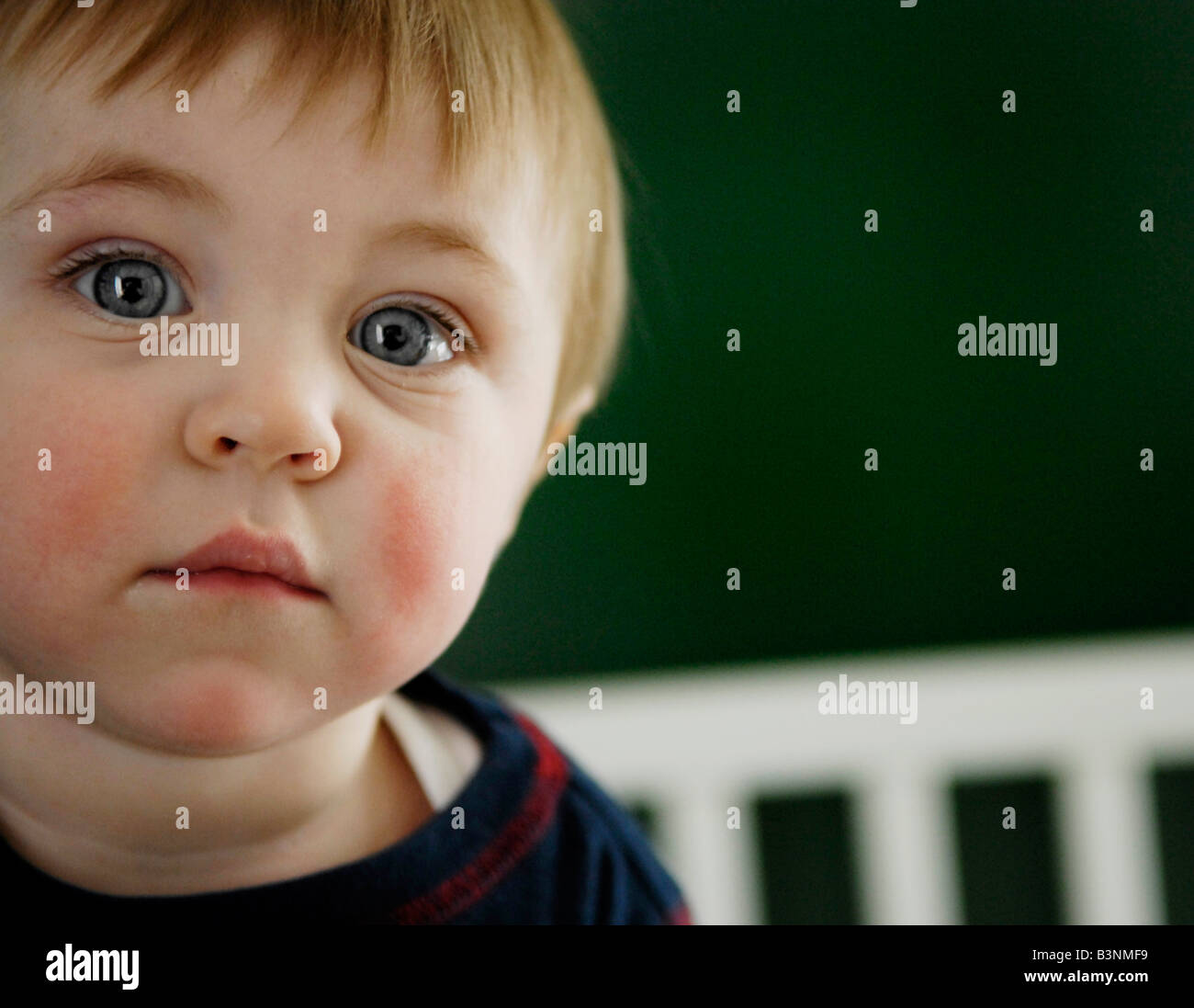 serious caucasian boy looks out from inside crib Stock Photo - Alamy