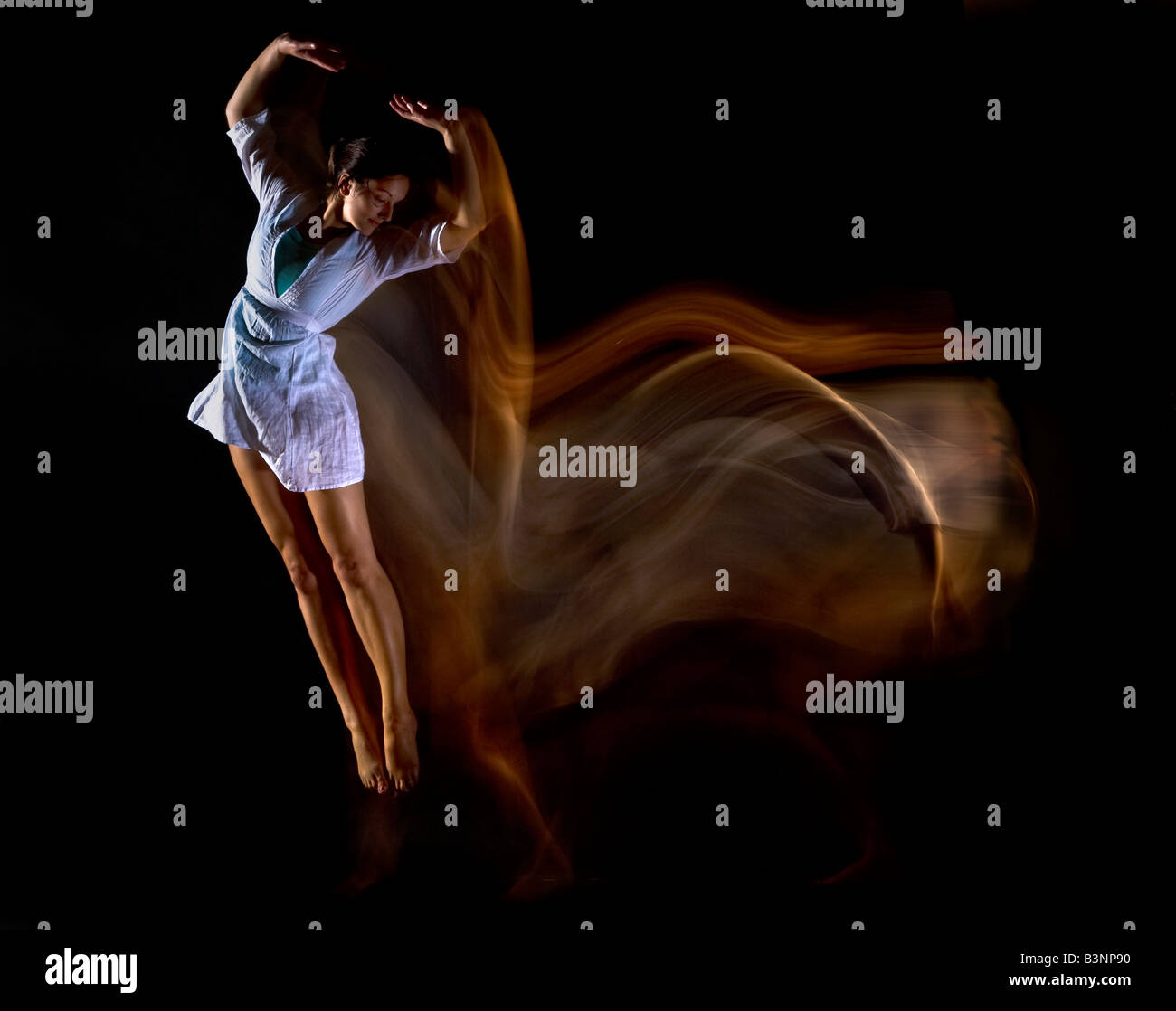 dancer jumping through the air showing motion as trails of light impact ...