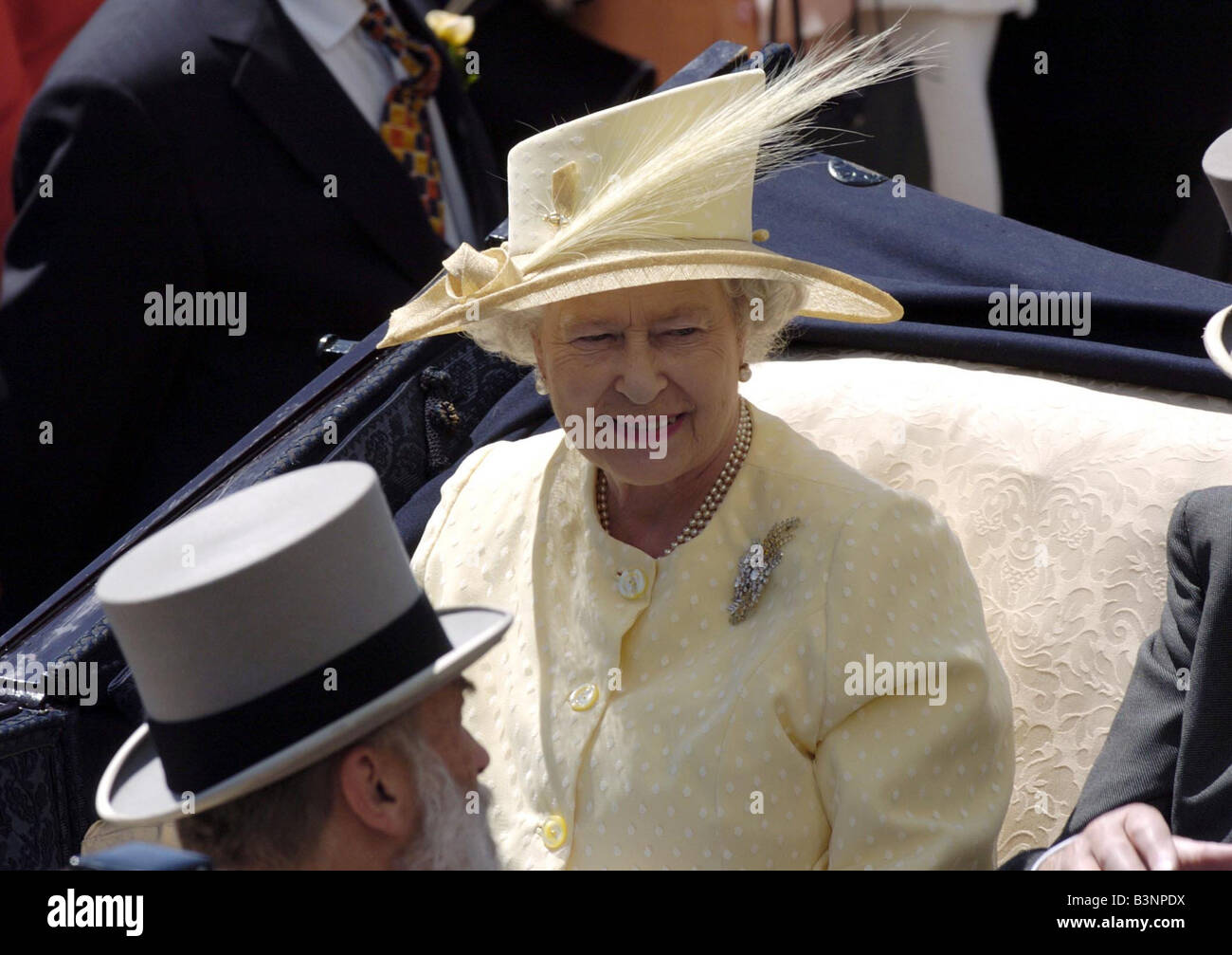 Queen Elizabeth II at Royal Ascot sitting in a cart yellow costume ...
