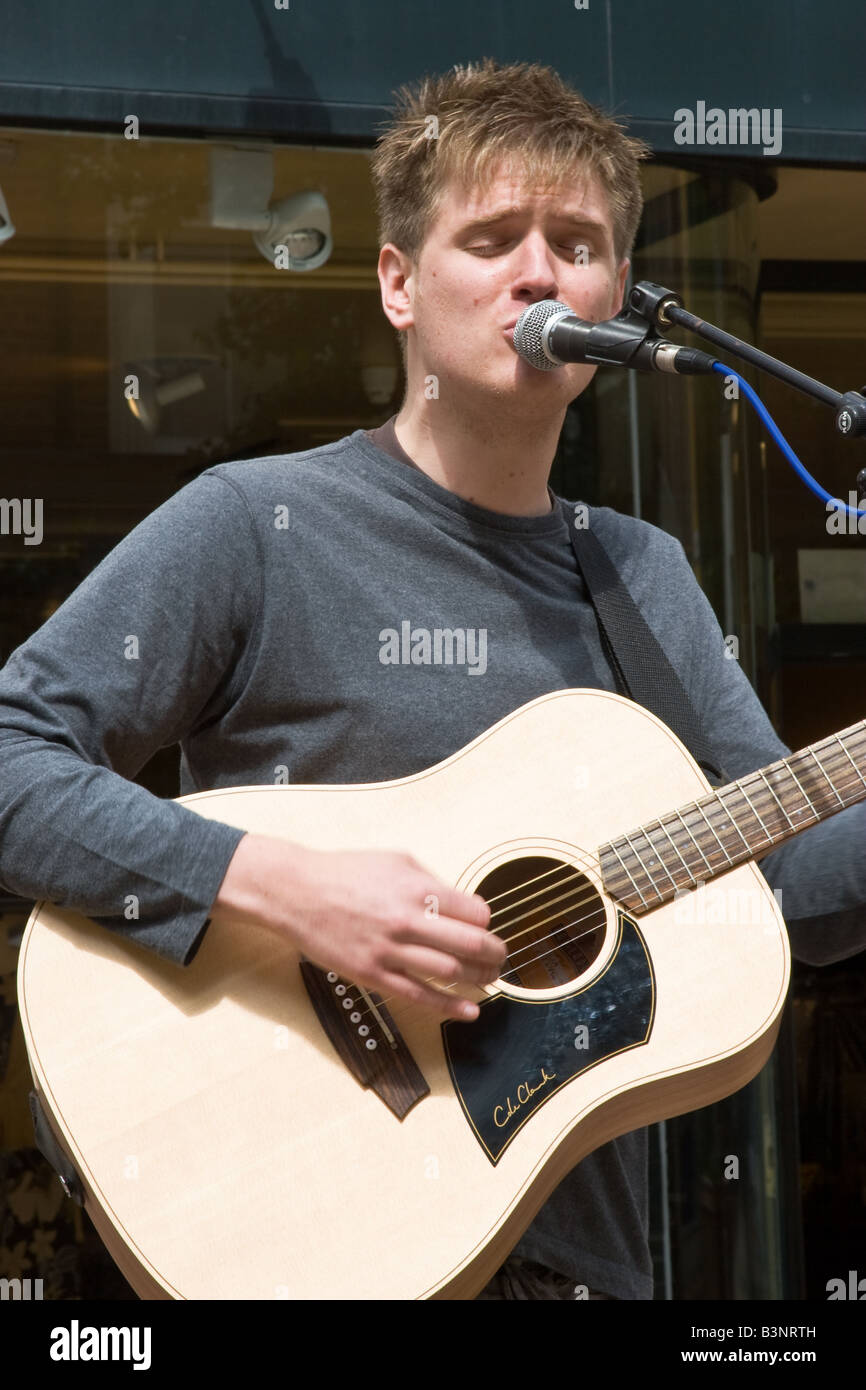 Busker with acoustic guitar sings in the street Stock Photo - Alamy