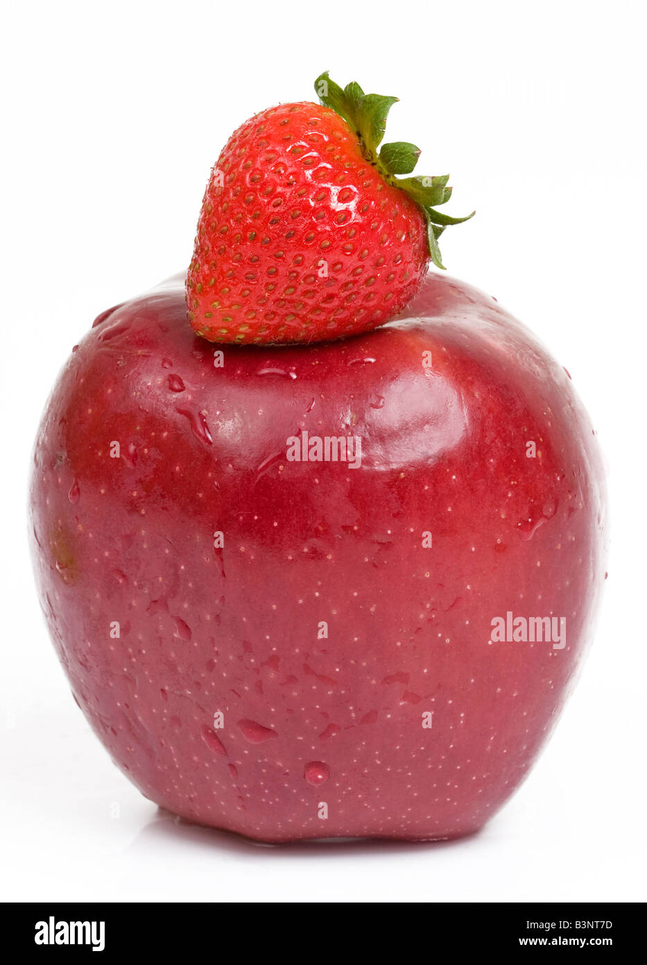 Fresh strawberry on top of a wet red apple Stock Photo - Alamy