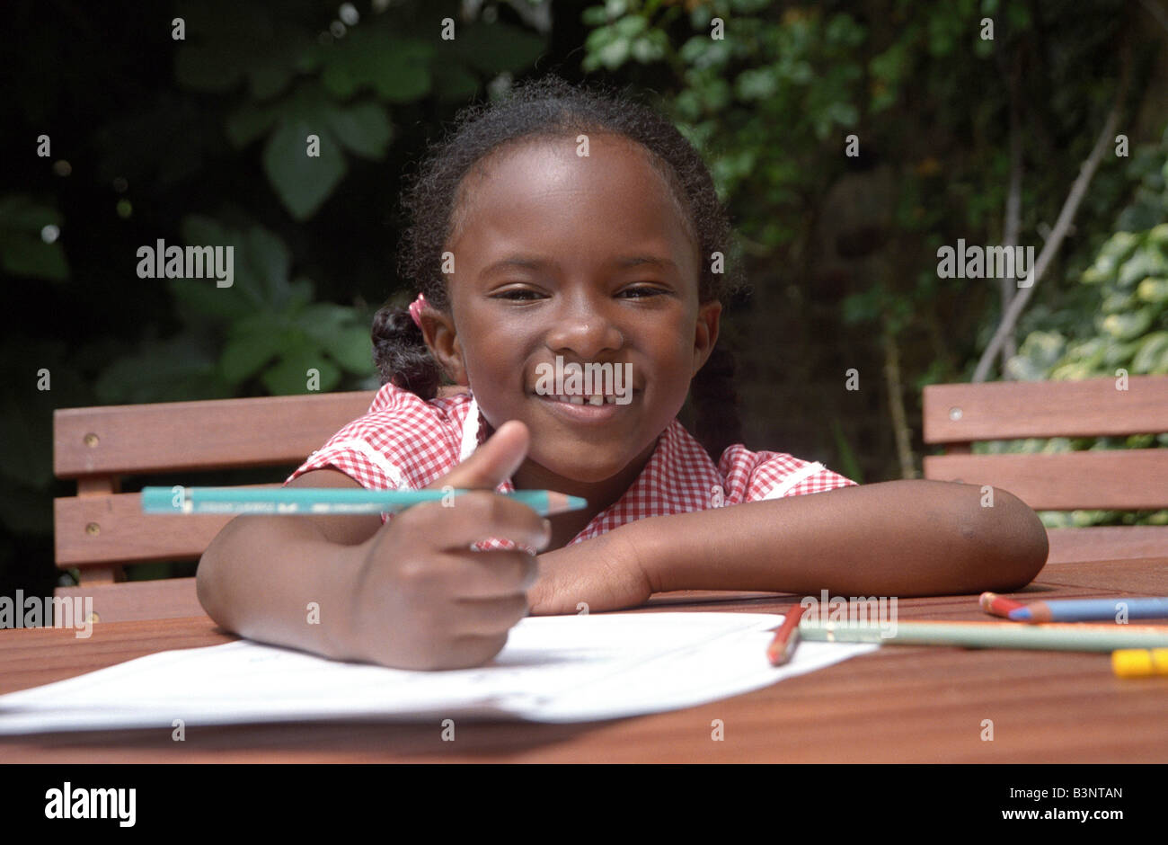 Little black girl doing homework in the garden Stock Photo - Alamy