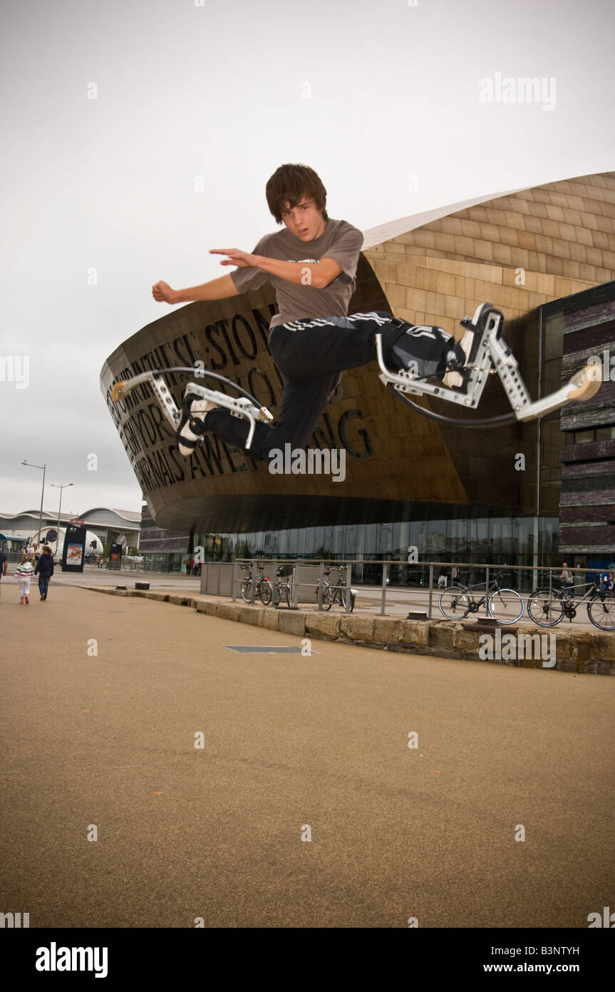 Young man on bouncy pogo stilts bockers doing acrobatic stunts outside ...