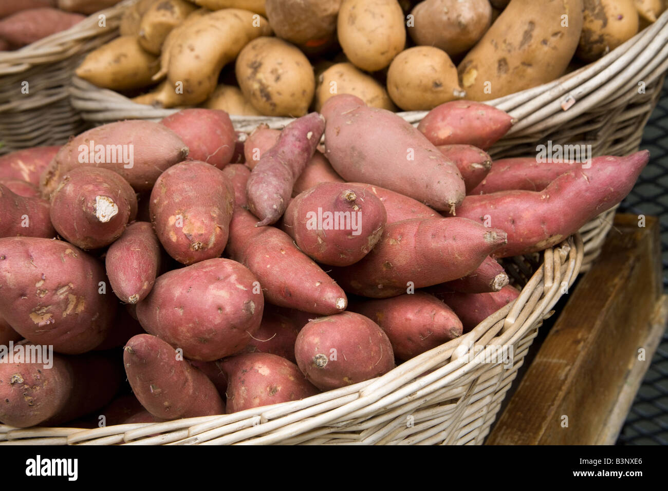 Two baskets of sweet potatoes (yams) for sale at an outdoor market ...