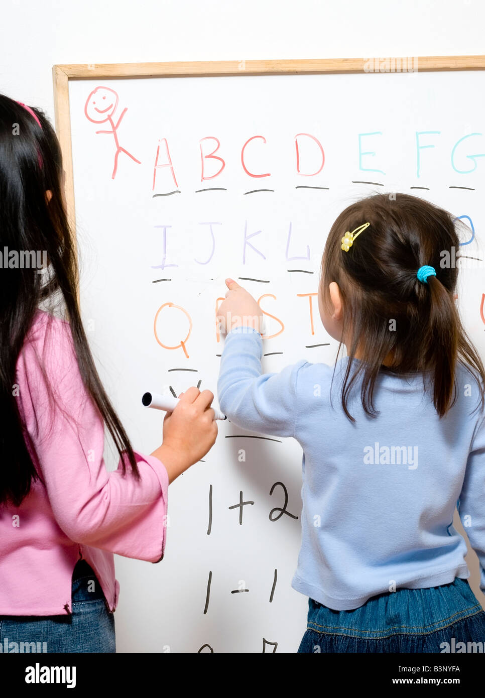 two young girls learning their numbers and letters Stock Photo - Alamy