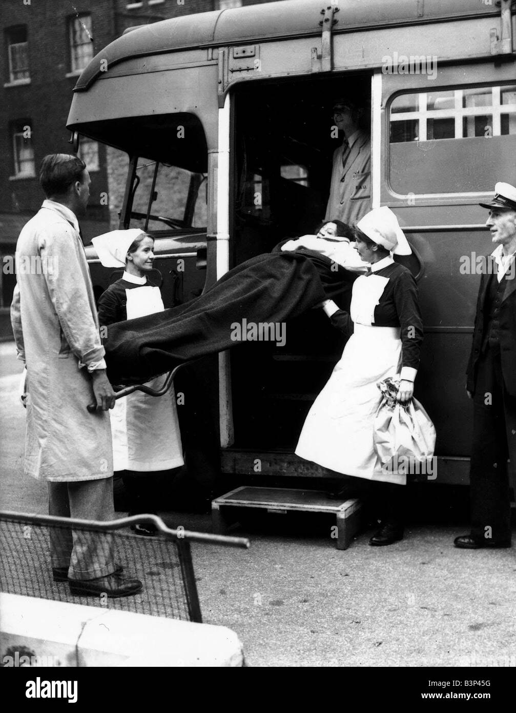 WW2 Air Raid Damage Injured woman civilian being carried onto a bus on ...