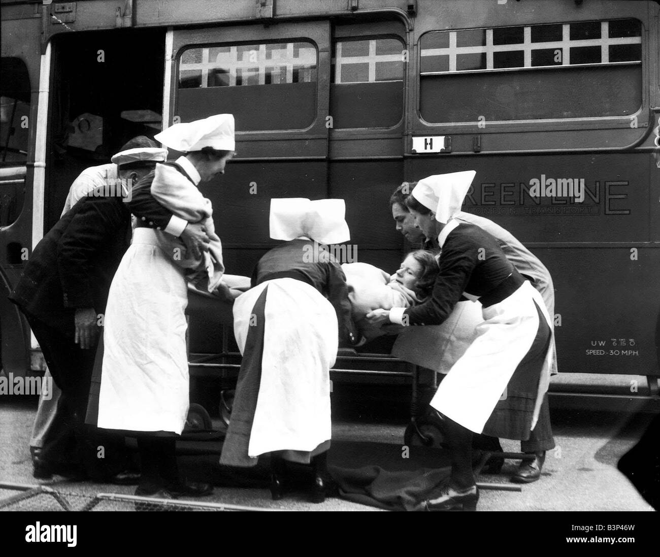 WW2 Nurses helps an injured woman on a stretcher during the blitz in ...