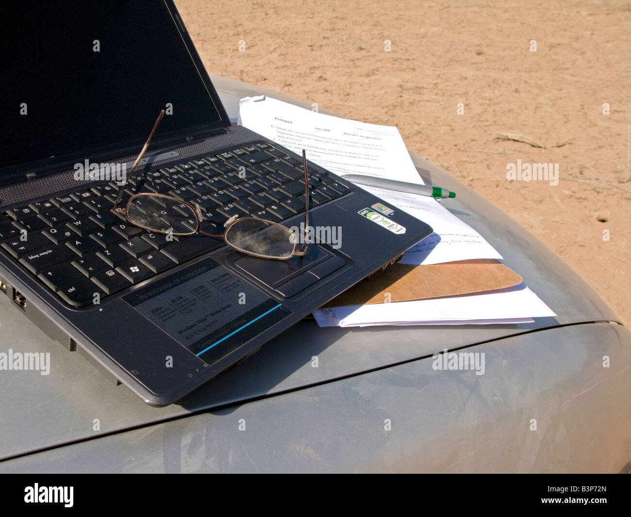 Laptop computer opened on a car with glasses in the desert Stock Photo ...