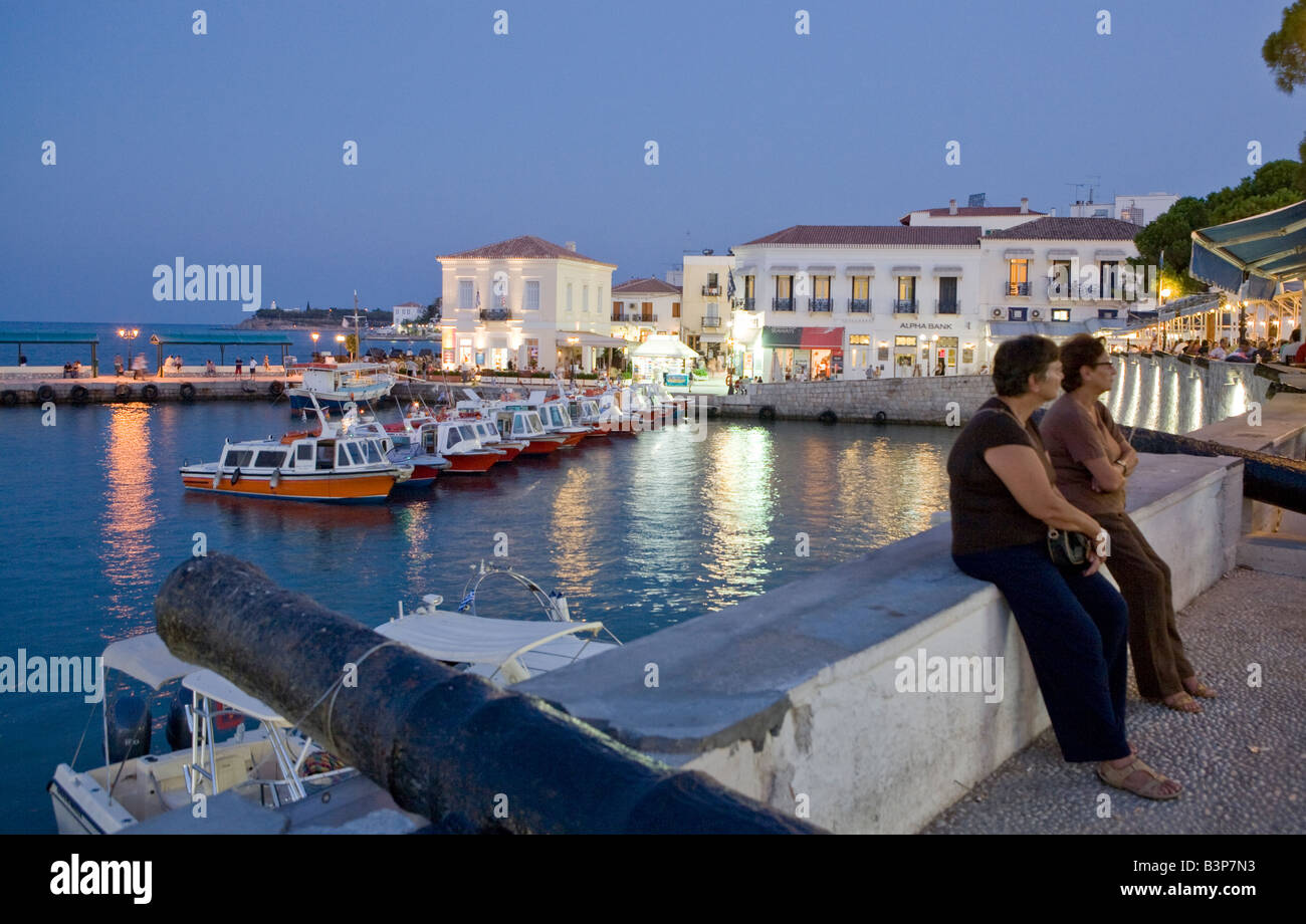 Tourists sitting on wall at new harbour, Spetses, Greece Stock Photo ...