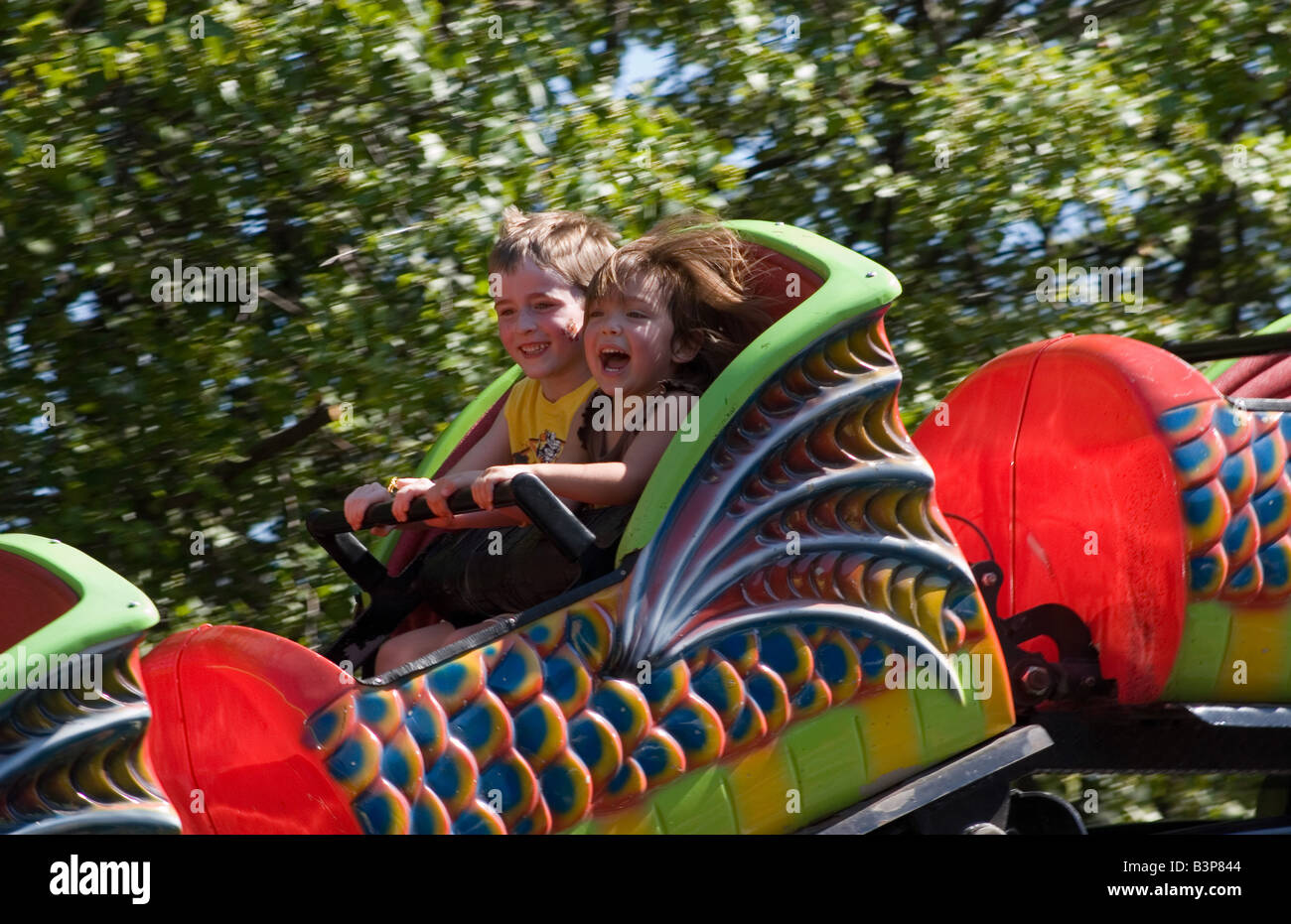 2 children having fun on a roller coaster Stock Photo - Alamy