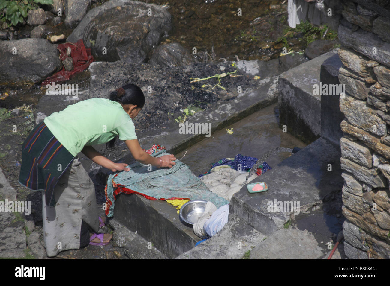 Nepalese woman washing clothes Stock Photo - Alamy