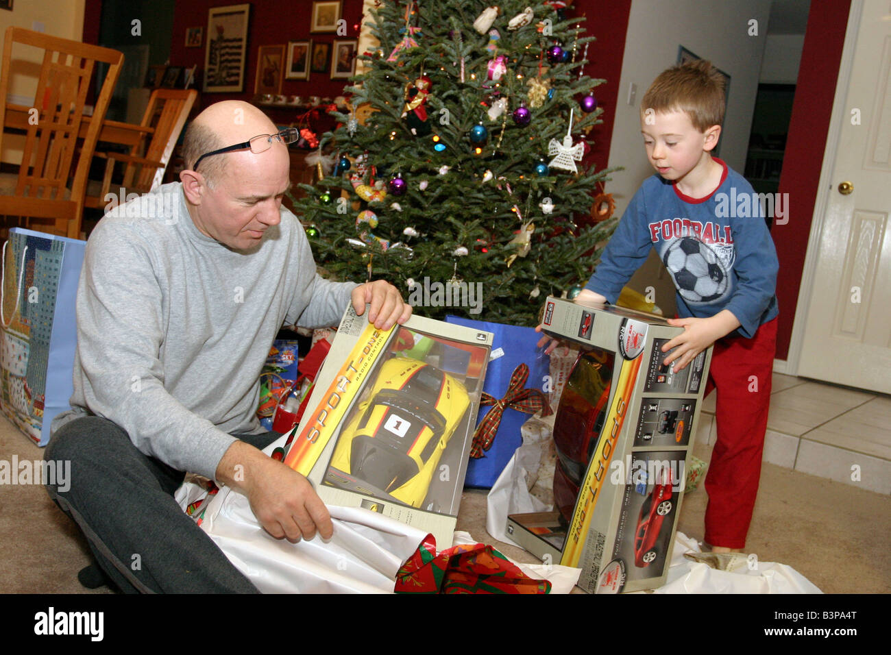 father and son opening presents on Christmas morning Stock Photo - Alamy