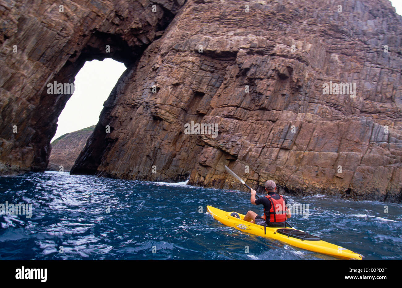 China, Hong Kong, Sai Kung peninsula. Sea kayaking through sea arches ...