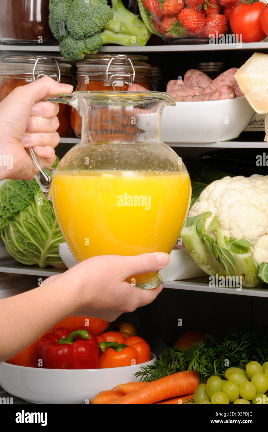 TAKING JUG OF FRESH ORANGE JUICE FROM REFRIGERATOR Stock Photo - Alamy