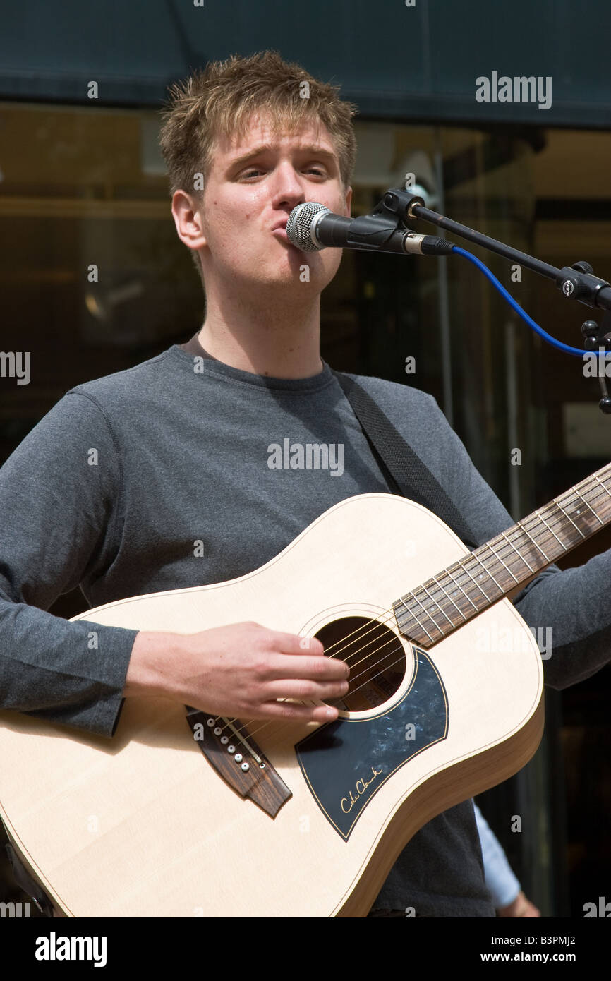 Busker with acoustic guitar sings in the street Stock Photo - Alamy