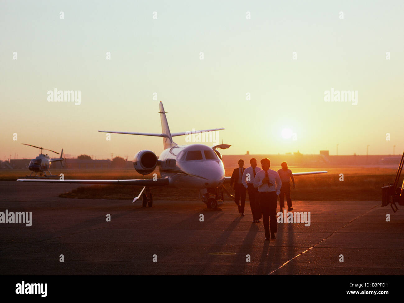 Businessmen deplaning a private corporate jet at sunrise Stock Photo ...