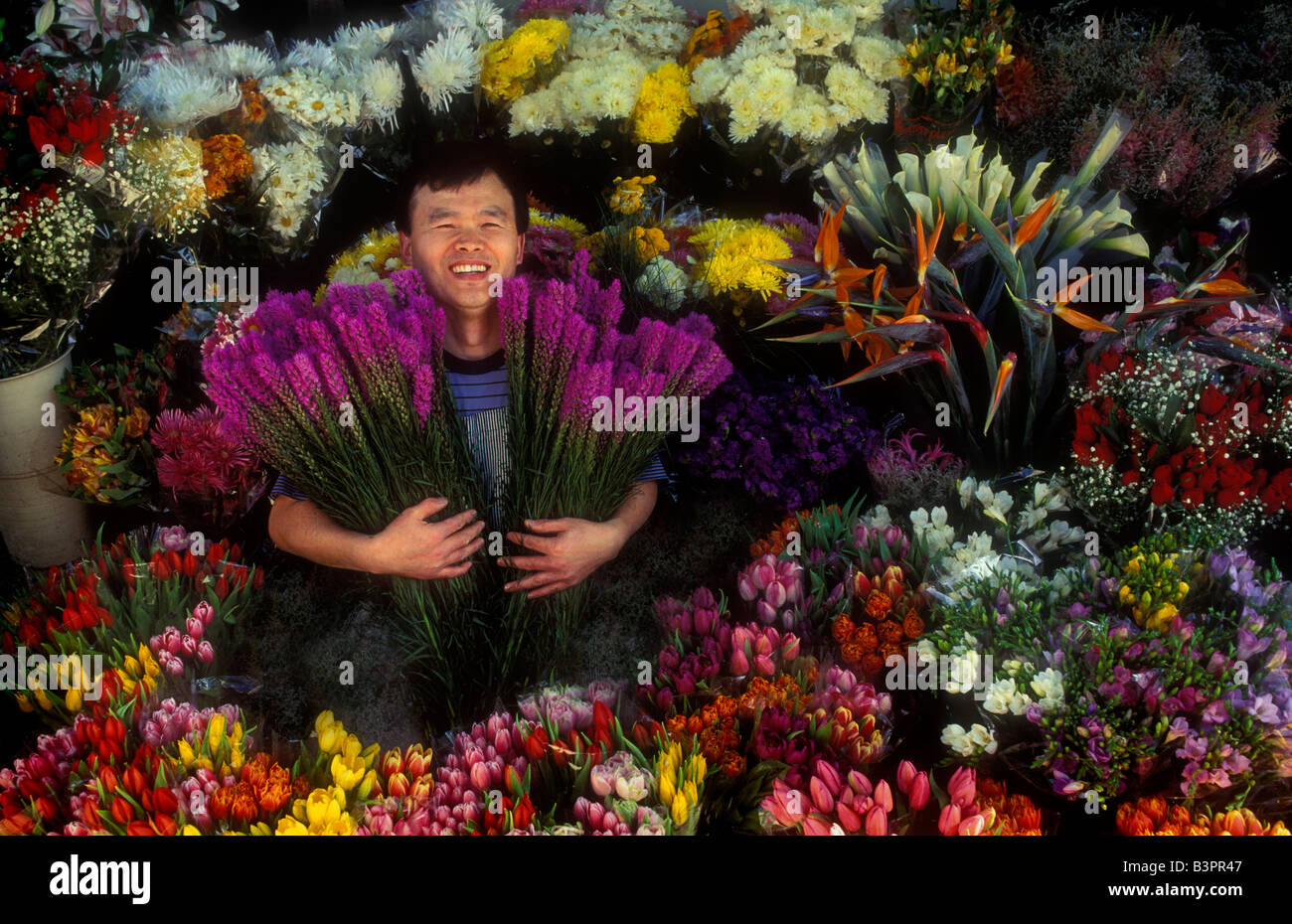 Asian man selling flowers Stock Photo - Alamy