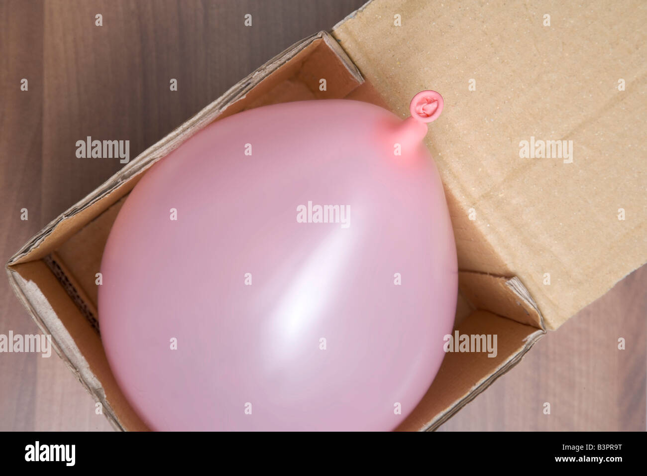 Pink balloon in a cardboard box Stock Photo - Alamy