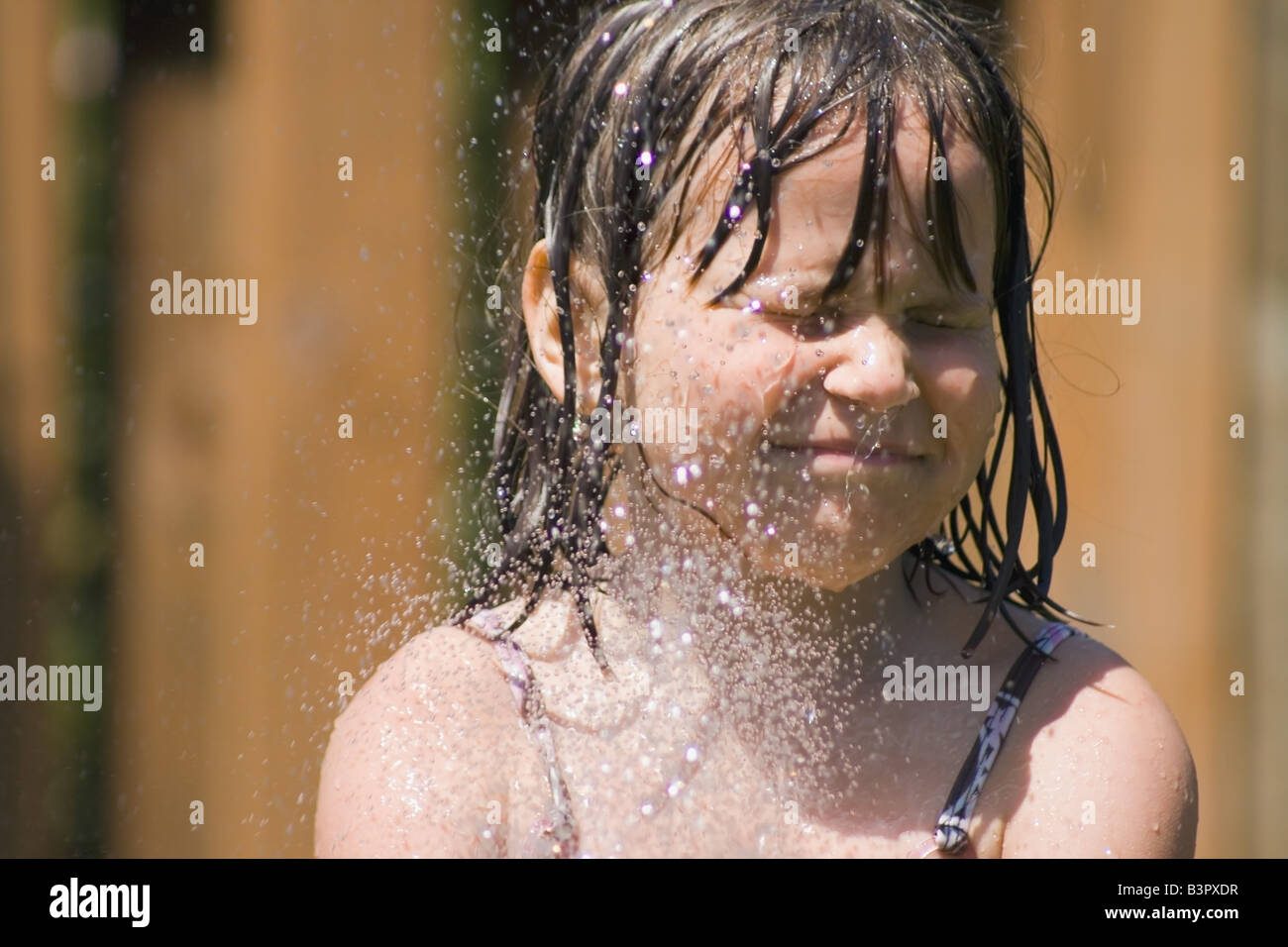 Young girl getting sprayed in the face with a garden hose Stock Photo ...