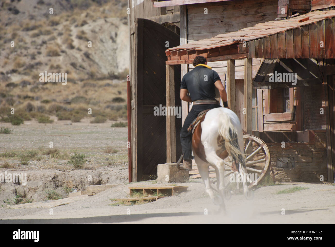 Cowboy riding away in a traditional American western style town Stock ...