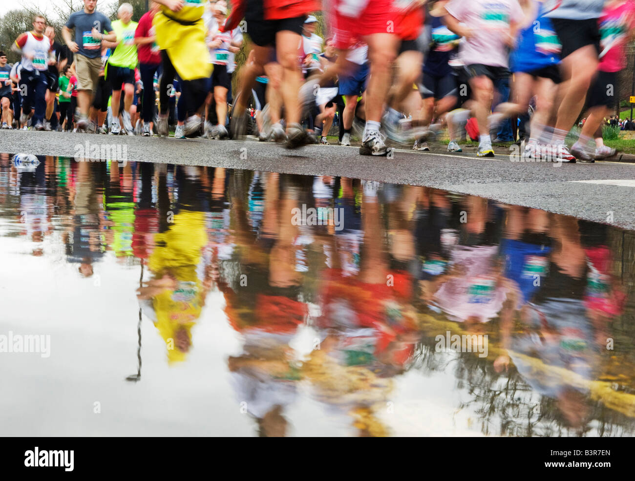 marathon runners reflected in puddle Stock Photo - Alamy