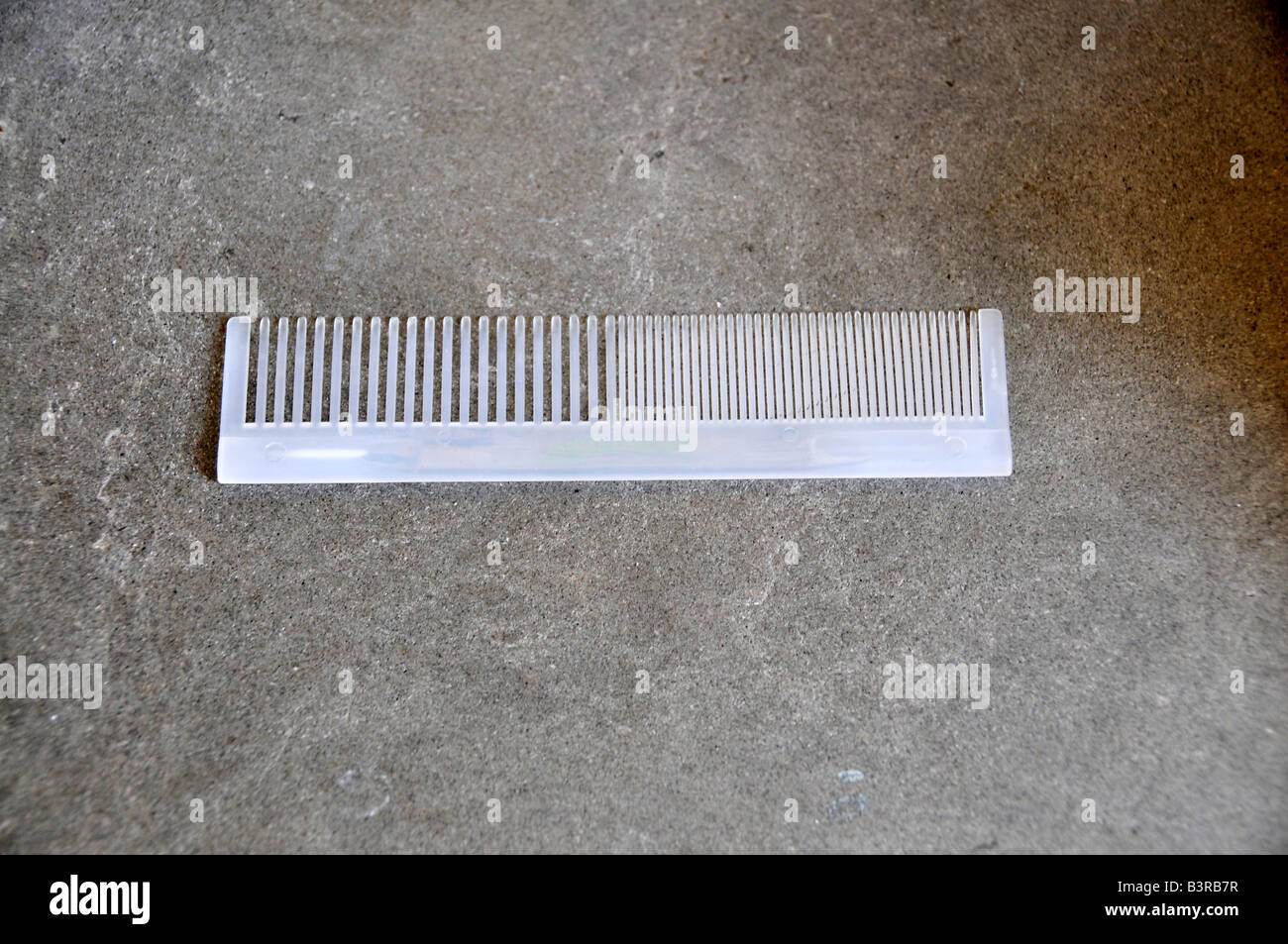 plastic comb on a grey background Stock Photo - Alamy