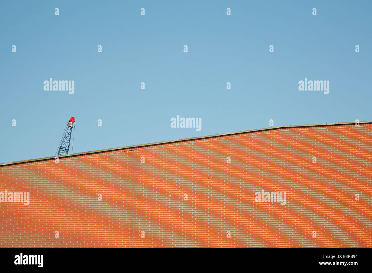 Brick wall, construction crane against blue sky, Scheveningen ...