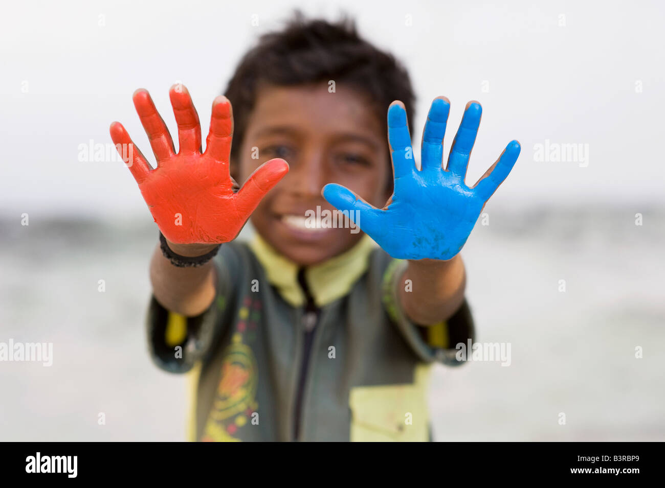 Indian boy with blue red painted hands Stock Photo - Alamy