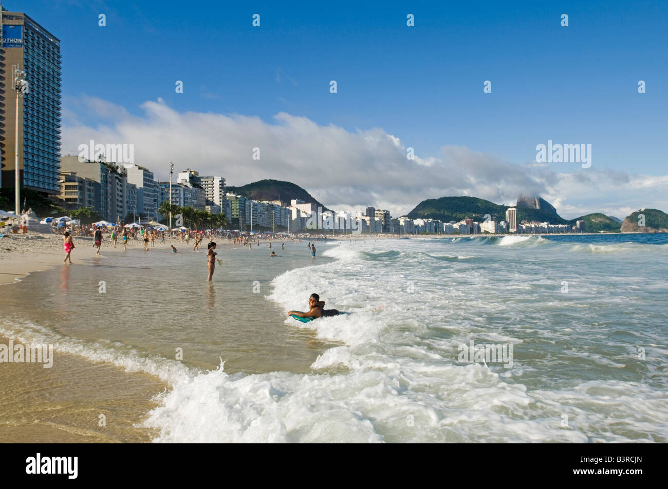 Copacabana beach in Rio De Janeiro with a young boy board surfing and ...
