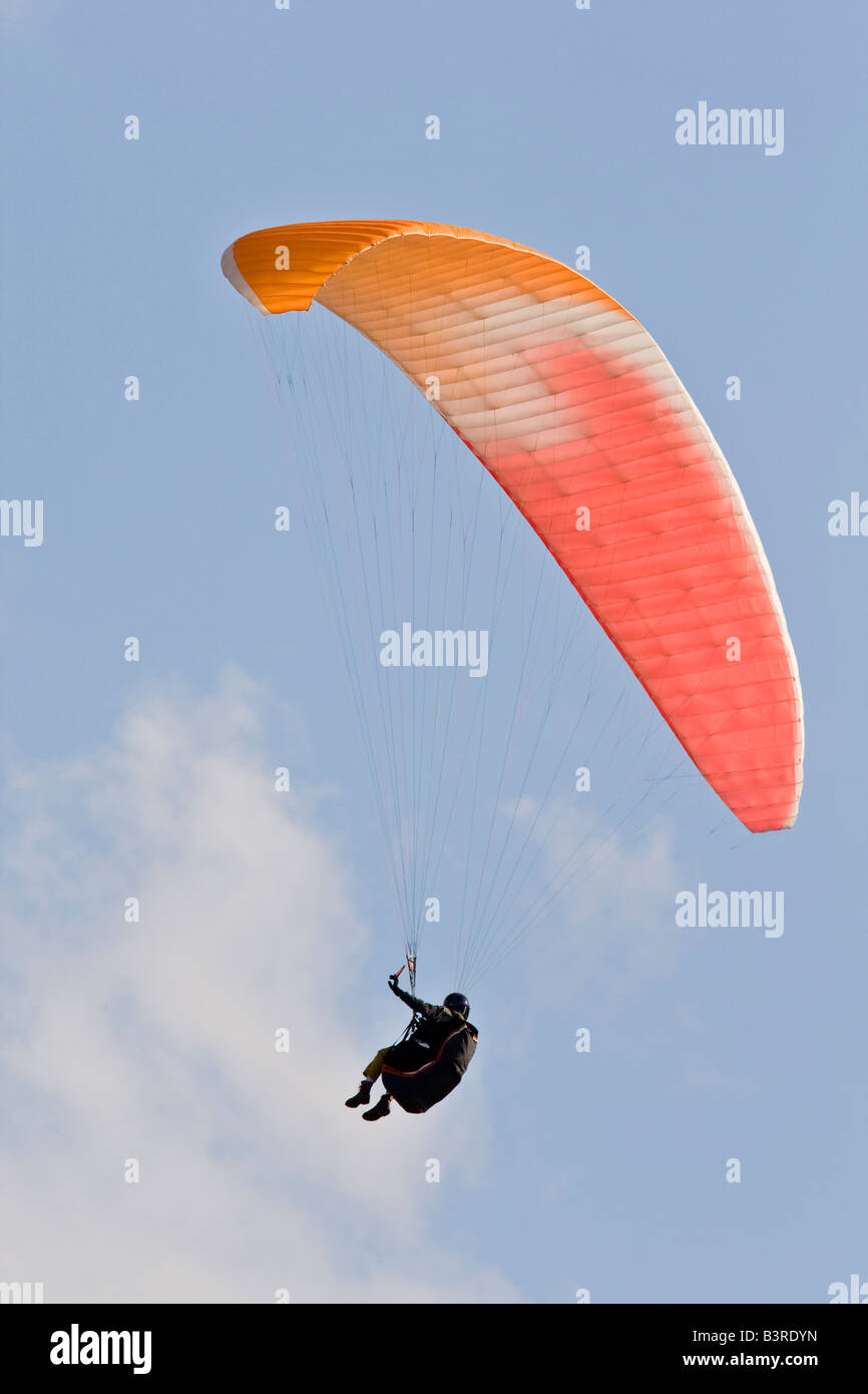 A man with a colorful paraglider flying in the sky Stock Photo - Alamy